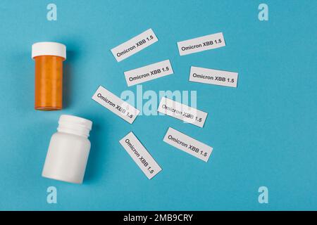 Top view of omicron xbb lettering on medical mask near pills on blue ...