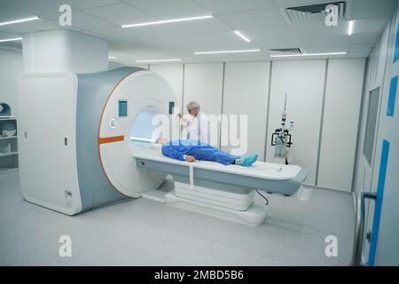 Doctor sends an elderly woman to the CT camera Stock Photo - Alamy