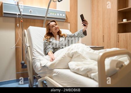Lady resting in hospital during treatment, looking at doctor Stock ...