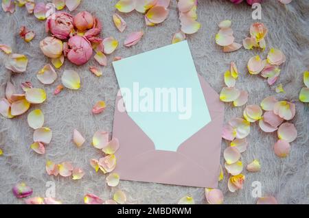 Craft pink envelope with small petals and rose buds on pink knitted ...