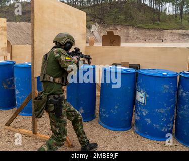 A Colombian team member fires his rifle at targets in a stimulated ...