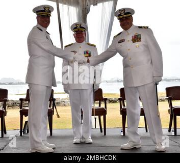 Rear Adm. Brendan McPherson (right) places the Coast Guard Cutter Pablo ...