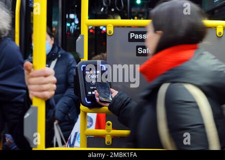 A person taps a smartphone to an OMNY contactless payment reader on a ...