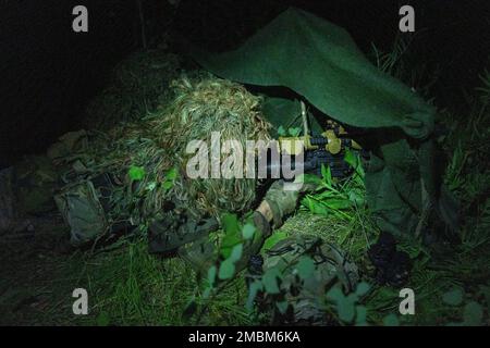A Greek Special Forces Sniper prepares his gear during a night-time ...
