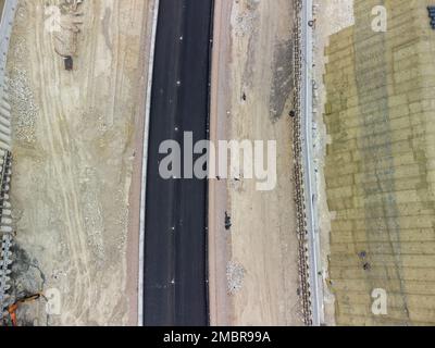 Mountain road constraction. Workers reinforce the slope over the new ...
