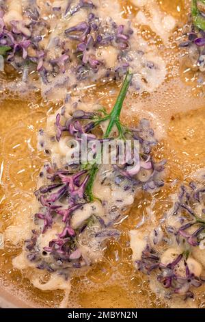 Homemade fried lilac flower with powdered sugar. Summer snack. Lilac ...