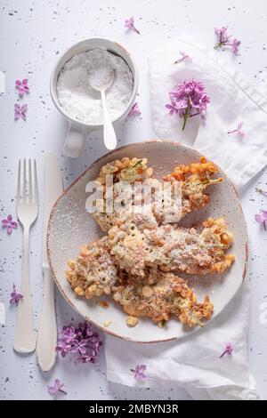 Sweet fried lilac flower in pancake dough. Sweet snack. Lilac flowers ...