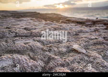 Sand and stones covered with crystalline salt on shore of Dead Sea ...