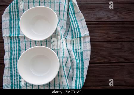 Empty plates on kitchen towel on wooden table, top view. Diet or ...