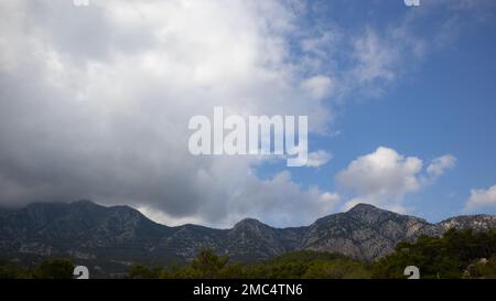 Contrast of clouds on mountain tops Stock Photo - Alamy