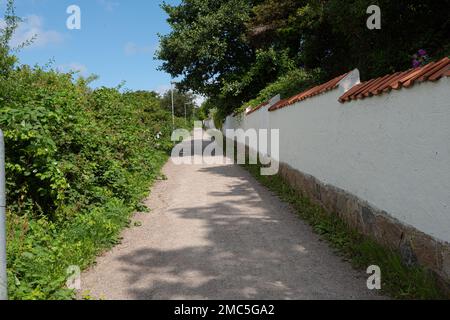 White brick wall by a narrow uphill path Stock Photo - Alamy