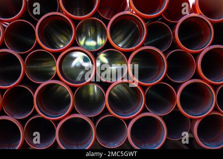 Large pile of orange plastic PVC pipes Stock Photo - Alamy