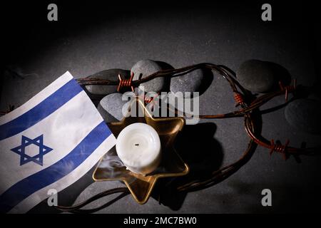 Burning candles, flag of Israel and barbed wire on dark background ...