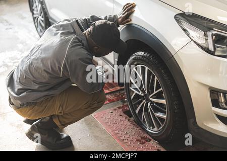 Mechanic checking geometry and suspension of a car wheel using ...