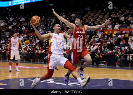 China's Zhao Rui, left, drives to the basket against Japan's Ryo Terashima during their FIBA ...