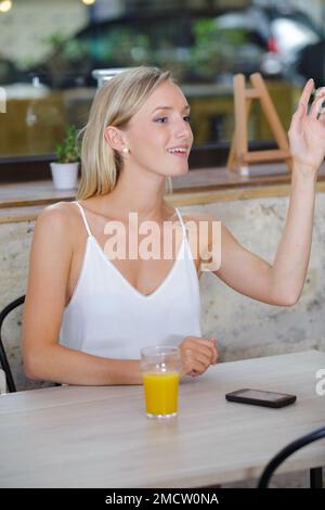 elegant woman calling for waiter Stock Photo - Alamy