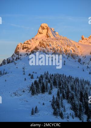 Mountain peak with sharp edges in warm sunrise warm light. Cold winter ...