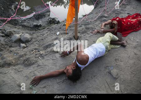Nepalese Hindu devotees prostrate on the ground outside a temple as a ...