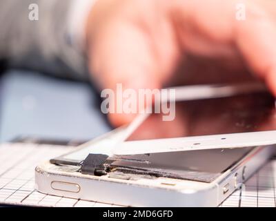 A technician repairs a smartphone in a laboratory with copy space ...