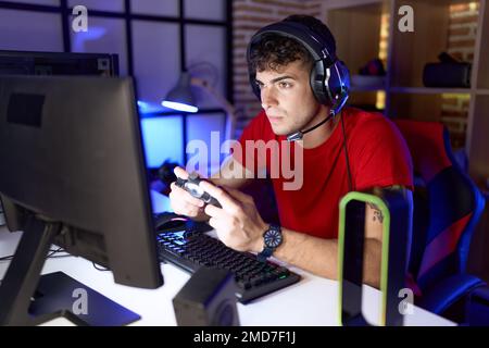 Young hispanic man streamer playing video game using smartphone at ...