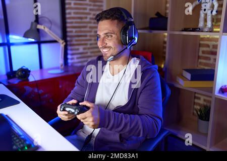 Young hispanic man streamer playing video game using smartphone at ...