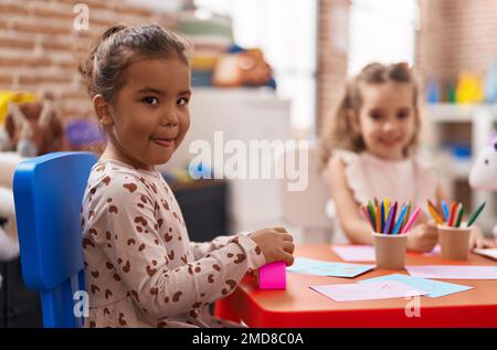 Two kids preschool students sitting on table drawing on paper at ...