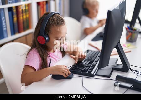 Adorable hispanic boy student using computer with stressed expression ...