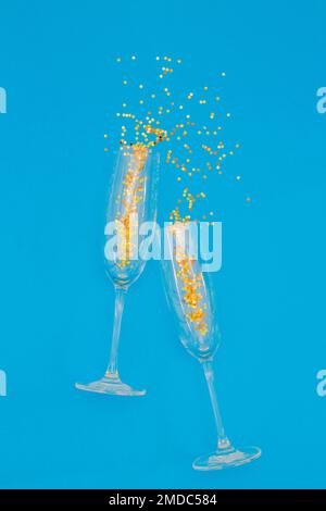 Champagne glass with beautiful golden confetti in shape of star on blue ...