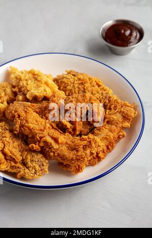 Chicken Popcorn, Wings and Tenders with BBQ Sauce on a plate on a gray ...