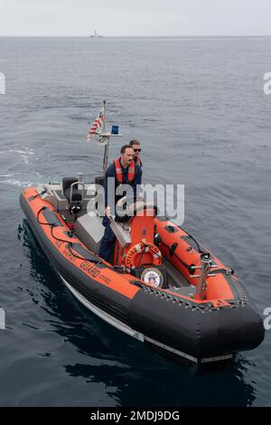 A US Coast Guard rigid hull inflatable escort boat speeds past a ...
