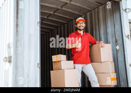 delivery man standing between several package boxes in container truck ...