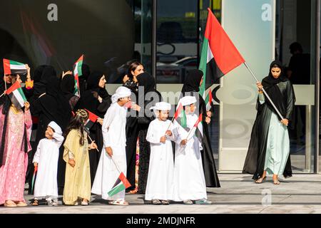 Dubai, UAE - November 28, 2022: children in traditional clothes wave ...