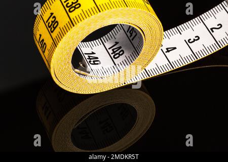 Measuring tape on black background Stock Photo - Alamy