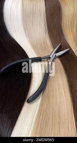 Strands of natural hair in different colors for extensions with tools ...