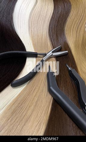 Strands of natural hair in different colors for extensions with tools ...