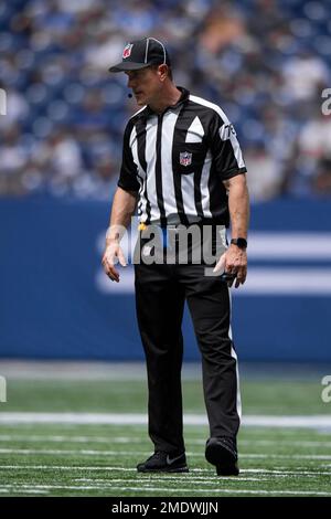 NFL umpire Alan Eck (76) carries the football down the field during an ...