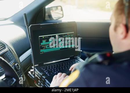 Database, laptop and a police officer in a car for security, urban law ...