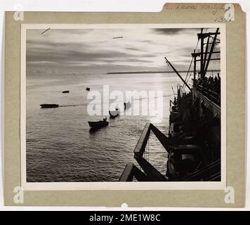 Army assault troops land from invasion craft while naval beach parties ...