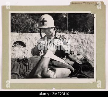 A wounded German soldier receives medical attention from American and ...