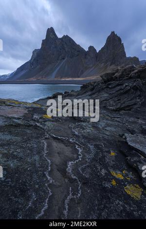 Picturesque scenery of waving sea washing rough shore near high snowy ...