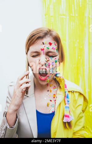 Woman with stickers on face screaming in front of wall Stock Photo - Alamy