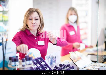 Pharmacist arranging medicines on shelf in store Stock Photo - Alamy