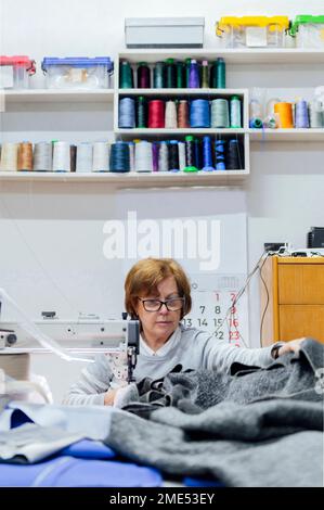 Woman sewing fabric in upholstery workshop Stock Photo - Alamy