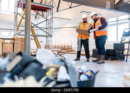 Engineers having discussion over document at construction site Stock ...