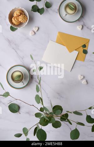 A blank card with envelope, pen and leaf is placed on white background ...