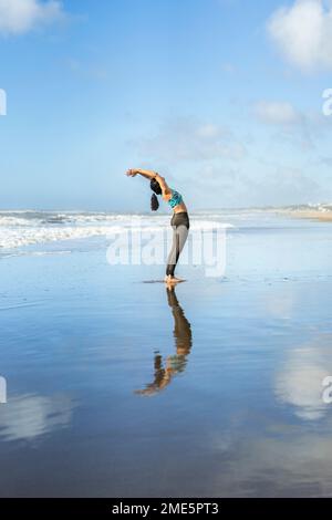 Woman doing backbend on beach Stock Photo - Alamy