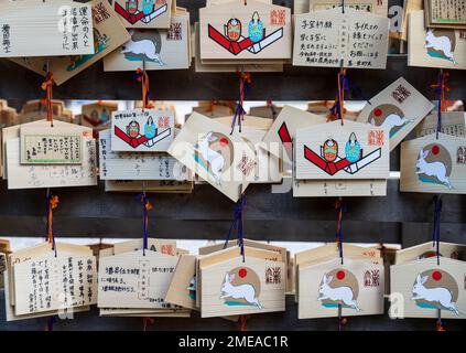 Wooden cards (ema) with prayers and wishes and white paper omikuji ...