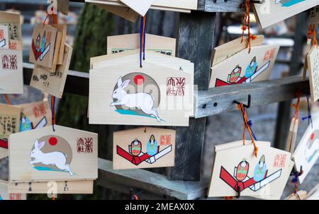 Wooden cards (ema) with prayers and wishes and white paper omikuji ...
