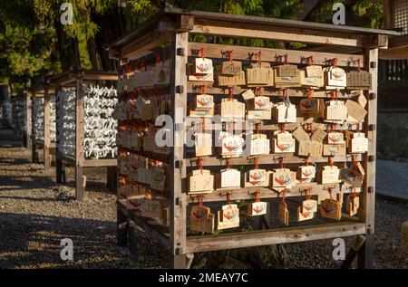 Wooden cards (ema) with prayers and wishes and white paper omikuji ...