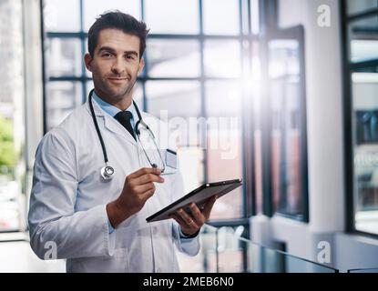 Checking my schedule for the day. a handsome young businessman standing ...